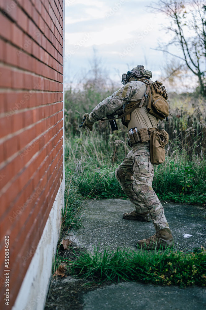Special forces operator in Multicam uniform perform CQB tactics training in abandoned building ...