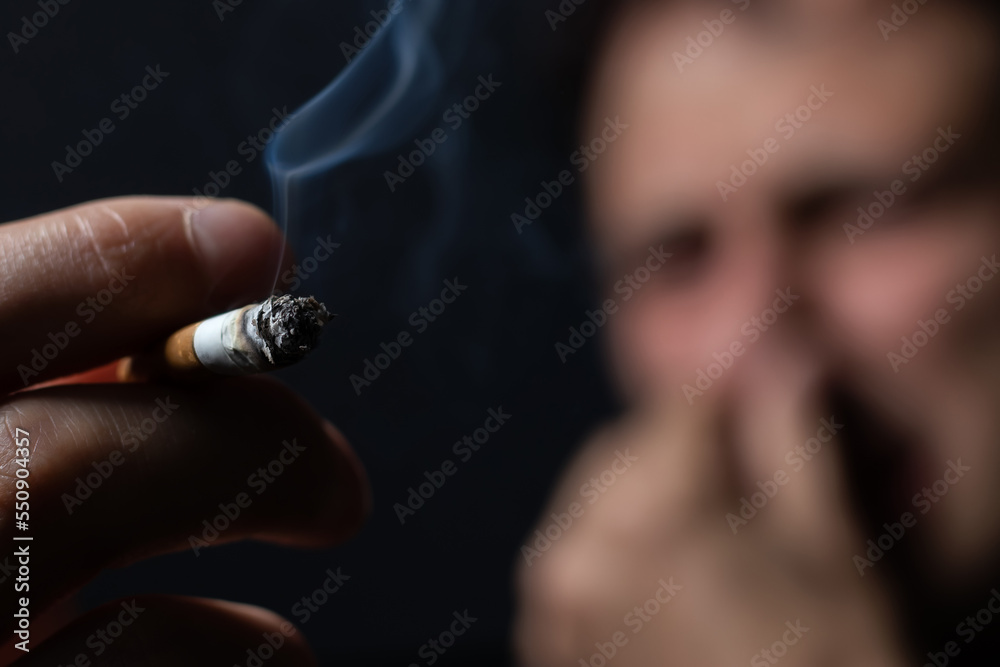 Passive smoking concept. Man is smoking cigarette and man is covering ...