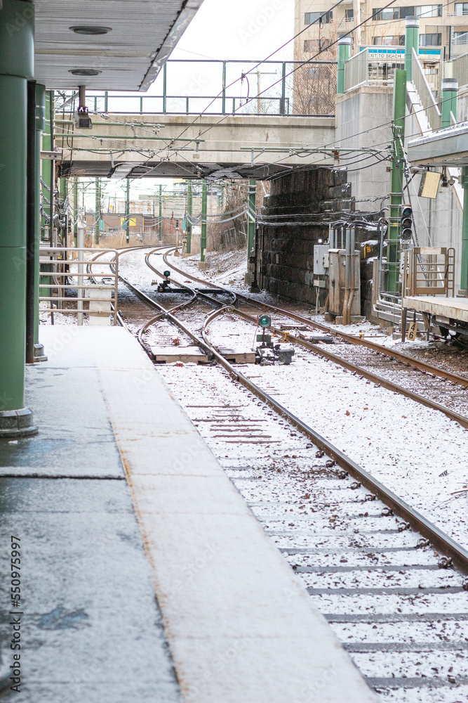 Snow covered train tracks seen from inside a train station during a ...