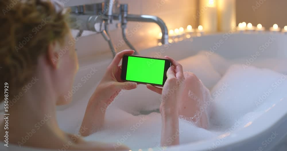 Relax woman, bath tub and green screen smartphone for movies streaming ...