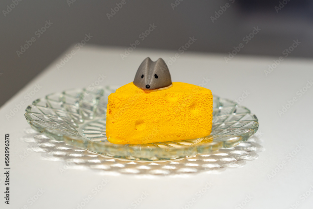 A single piece of cheesecake shaped like a slice of a cheese wheel ...