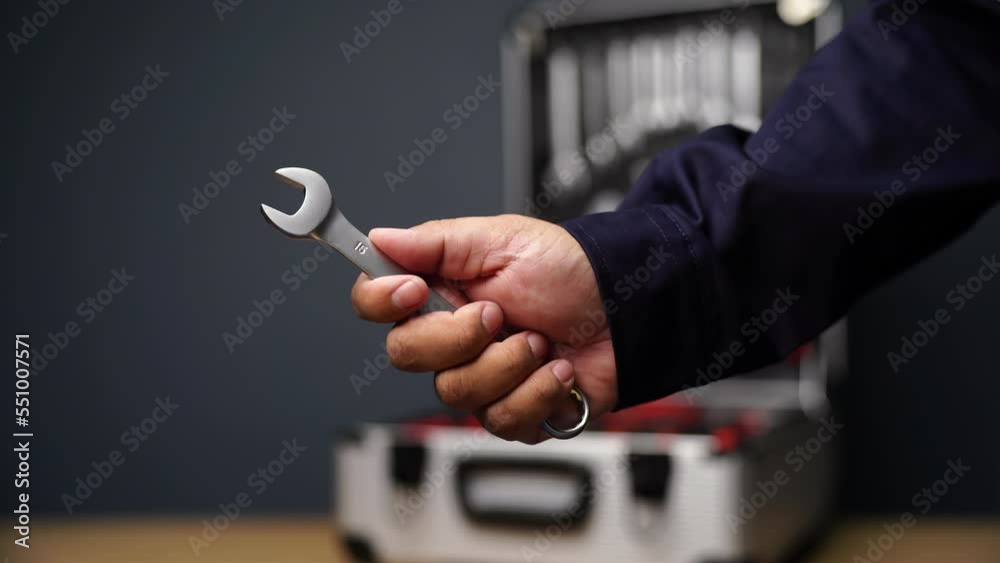 Mechanic holding open-ended wrench from toolbox. Wrench. Car repair kit ...