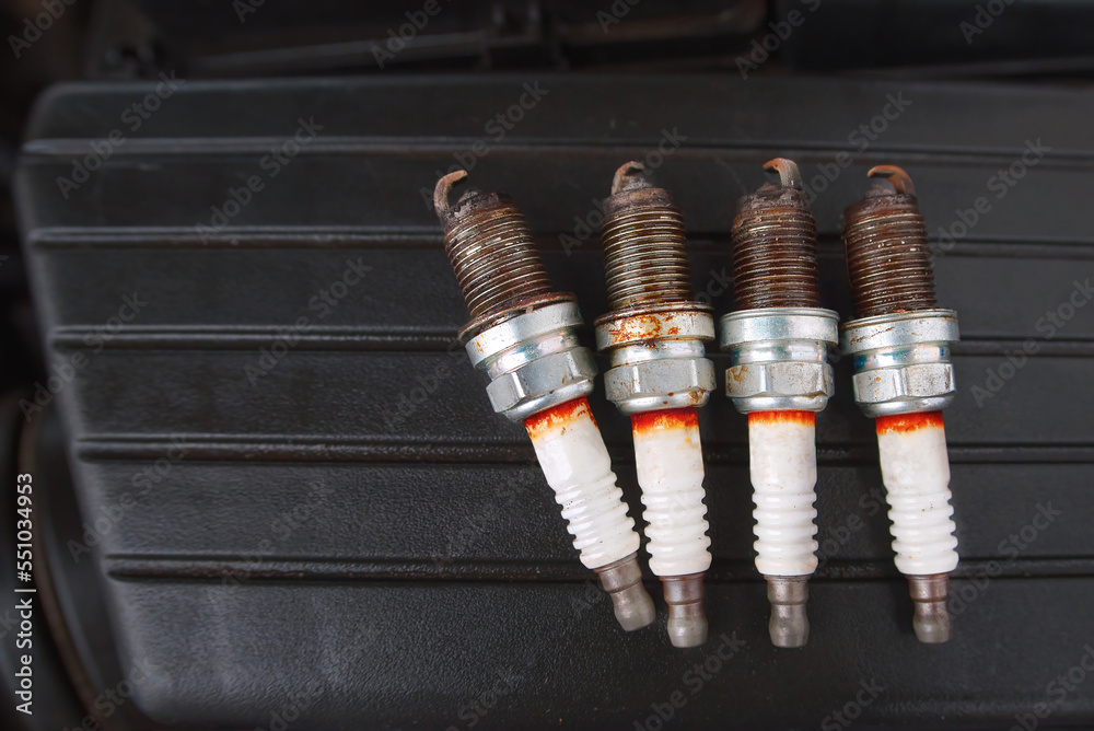 Burned spark plugs with worn electrodes. Used and damaged four spark ...