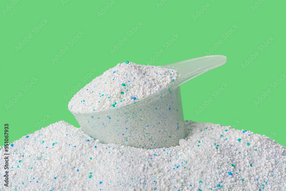 washing powder and a plastic spoon on a green background Stock Photo ...