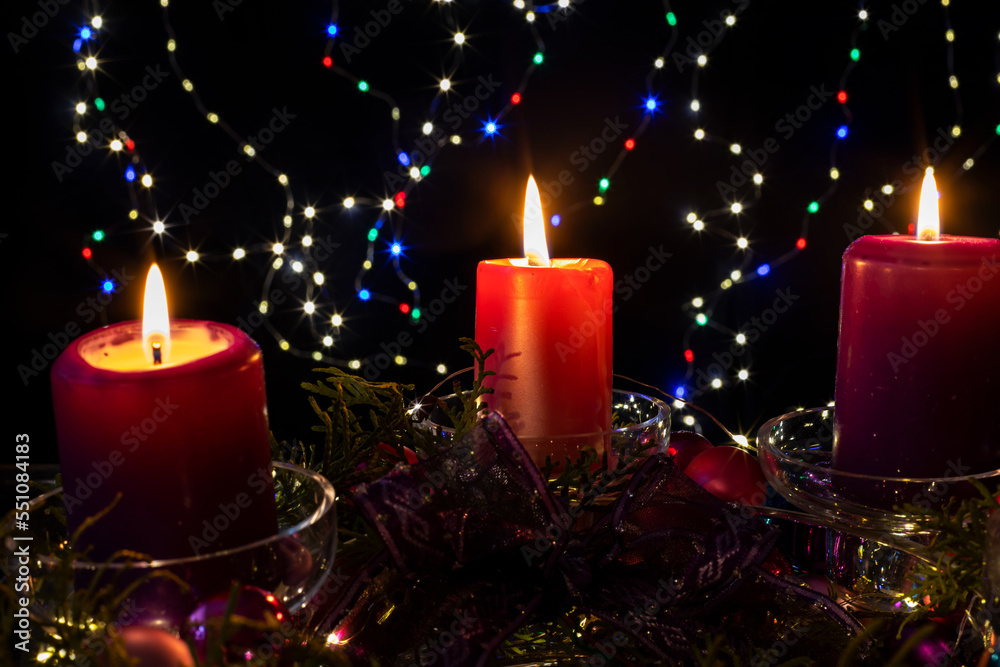 Three candles glow on Advent Wreath. Lighting the third candle on the ...