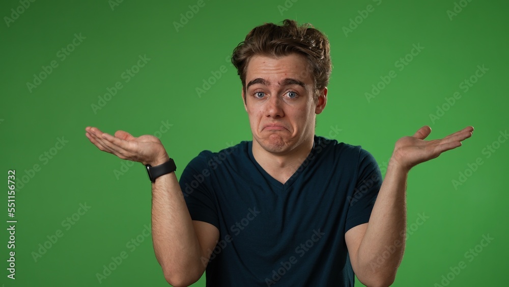 Portrait of happy young man 20s shrugging shoulders and gesturing I do ...