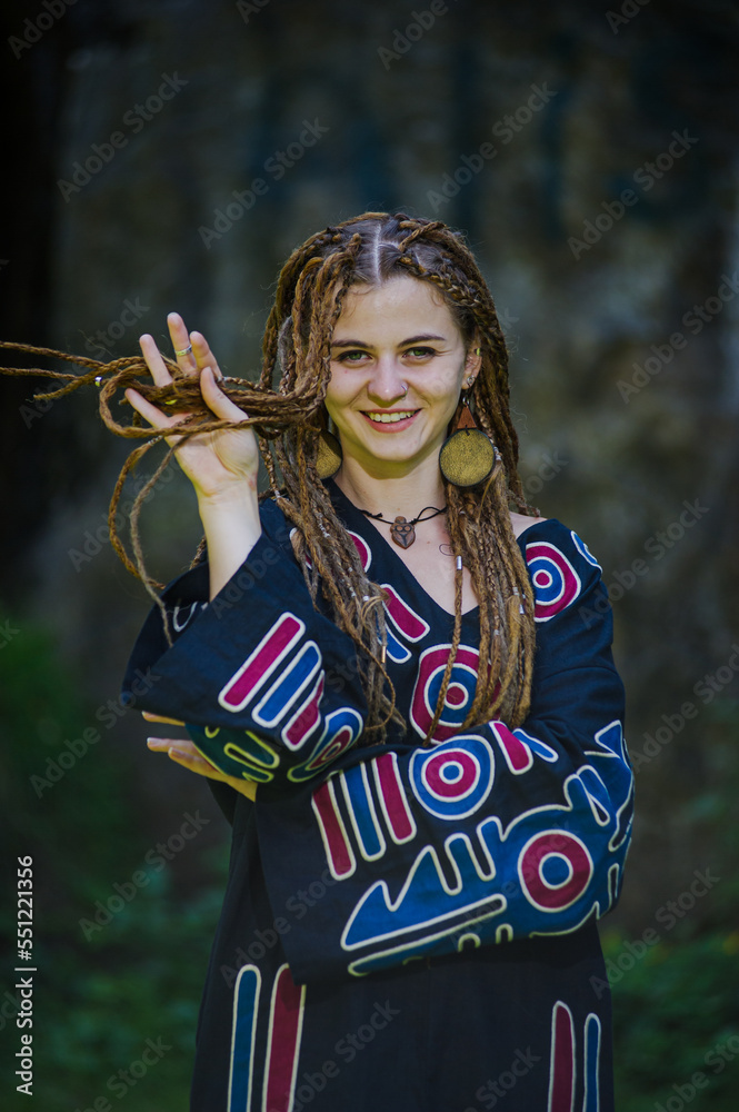 Beautiful girl with dreadlocks, dressed hippie style,poses outdoors ...