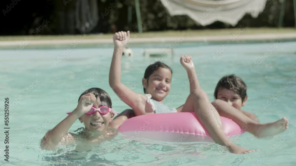 Vidéo Stock Happy children playing with rubber ring in swimming pool on ...