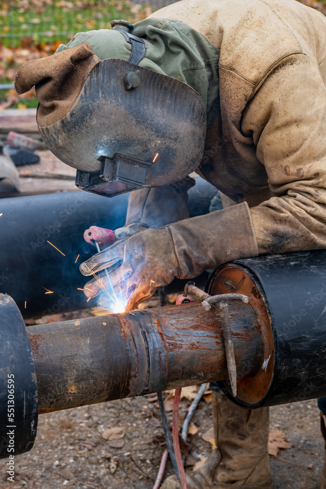 Soudure des tuyaux d'un réseau de chaleur par un soudeur. Chauffage ...