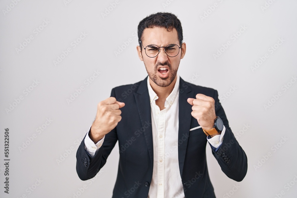 Handsome business hispanic man standing over white background angry and ...