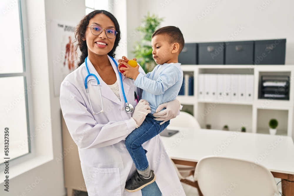 Mother and son pediatrician and patient hugging each other at clinic ...