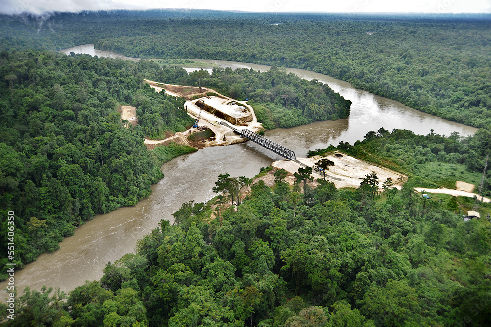 PNG-LNG project workers construct a new bridge over a river in the ...