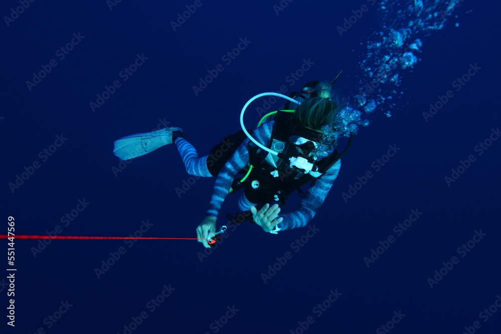 Silhouette of scuba diver completing safety stance with SMB device ...