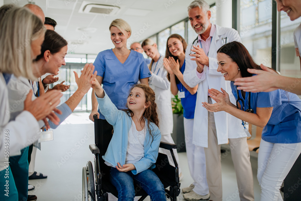 Medical staff clapping to little girl patient who recovered from ...