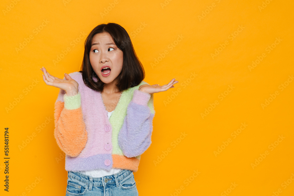 Confused asian girl shrugging shoulders to hold a copy space isolated ...