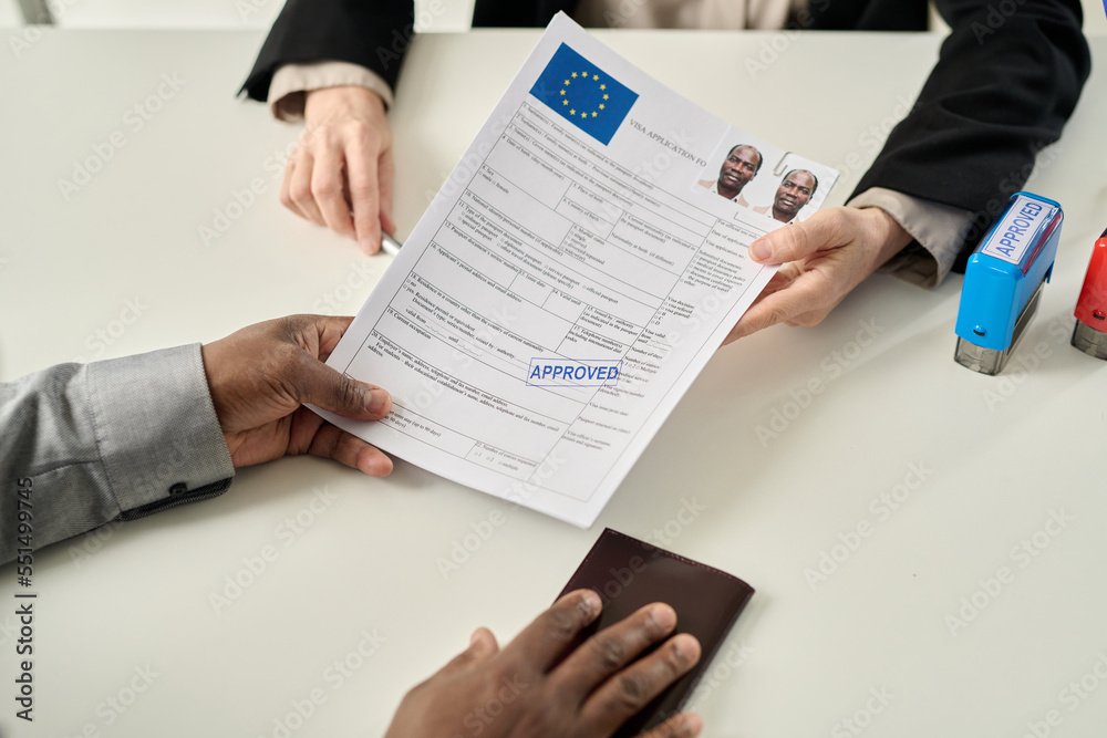 Top view closeup of black man holding approved visa application form in ...