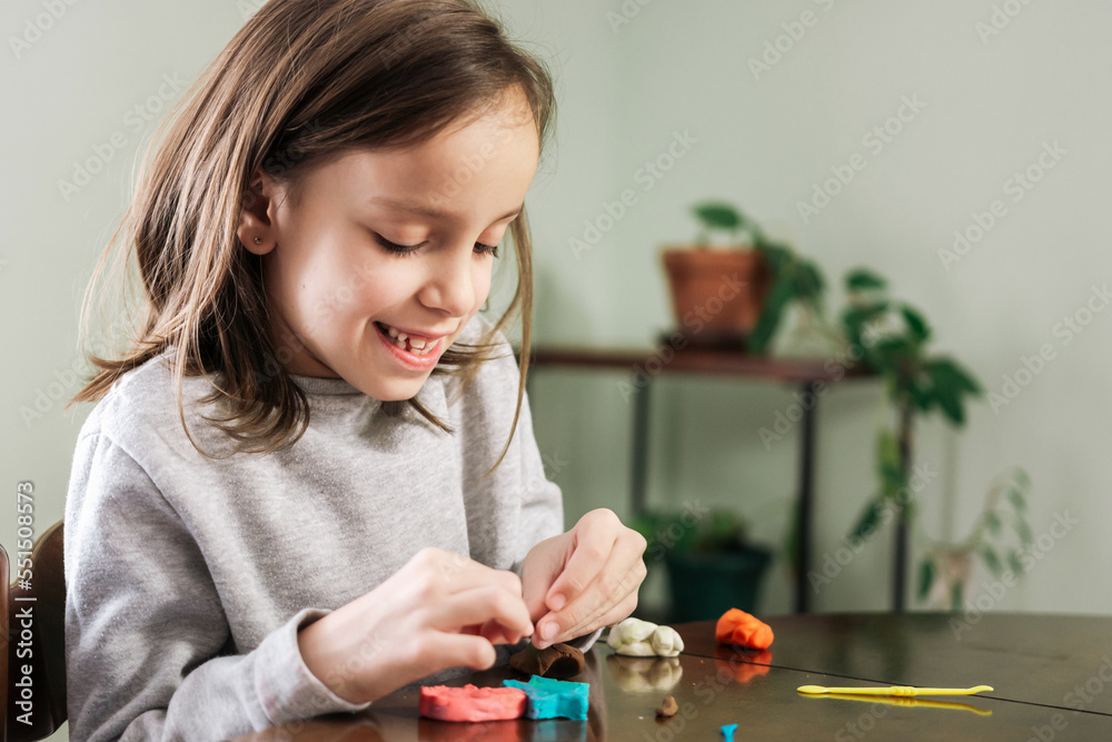 Cute girl making shapes of plasticine modeling clay Stock Photo | Adobe ...