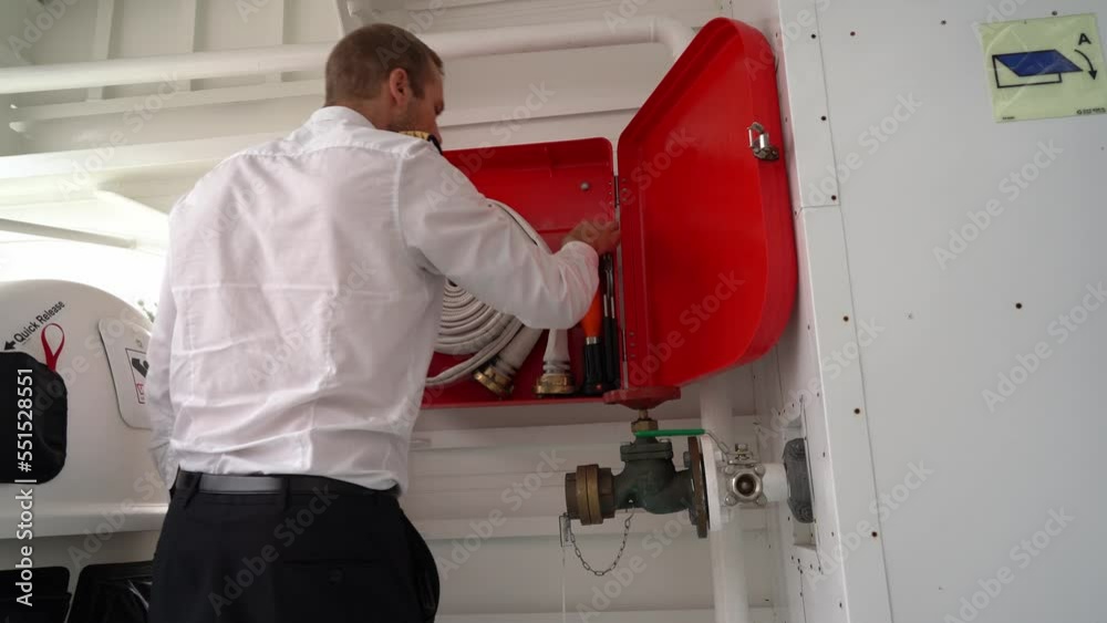 Ships captain inspecting firehose - Firefighting equipment onboard ...