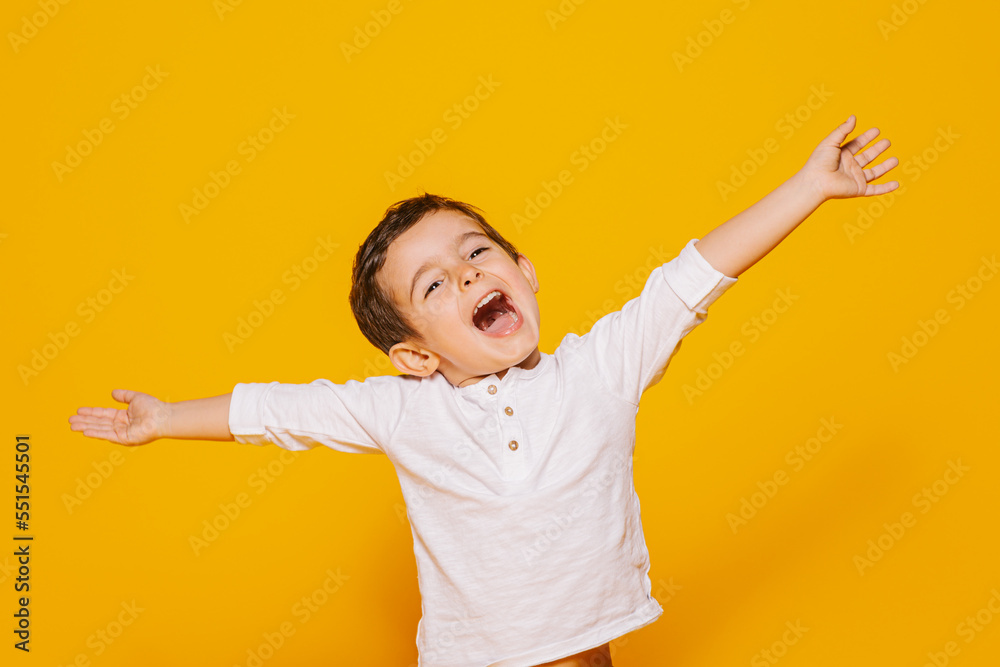 Excited little boy raising arms Stock Photo | Adobe Stock