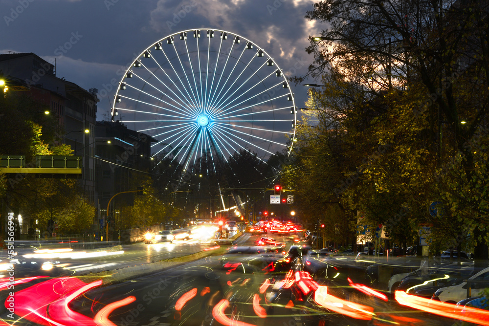Christmas Holidays, illuminated Ferris wheel with traffic flowing along ...
