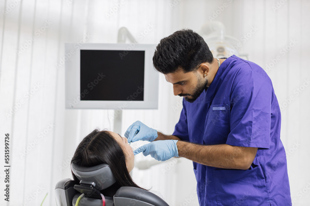 Side view of bearded male doctor in white uniform and gloves, making ...