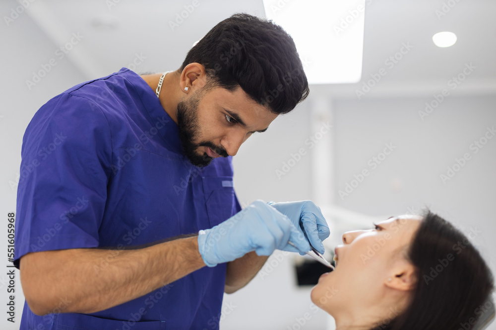 Side view of bearded male doctor in white uniform and gloves, making ...