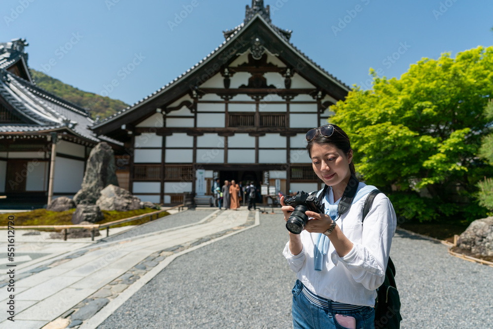asian Japanese woman photographer checking photos in slr camera on ...