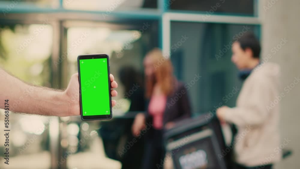 Person showing greenscreen display on smartphone outside, courier ...