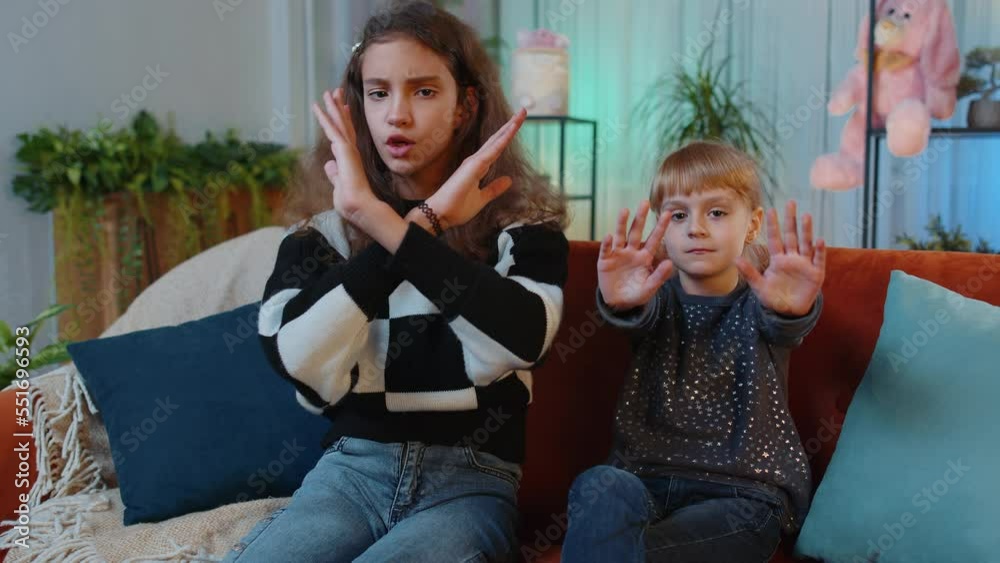 Child and little sister kid girls say no hold palm folded crossed hands ...