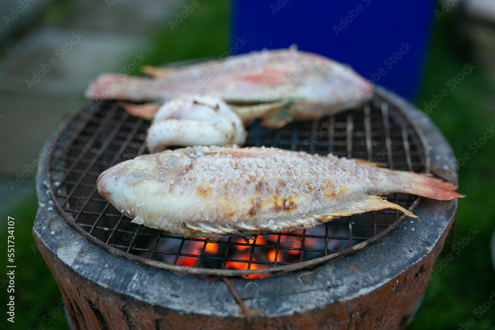 Salt-Crusted Grilled Fish. Red Tilapia Fish on a charcoal grill. Stock ...
