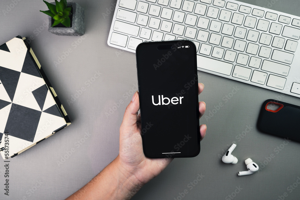 Girl holding a smartphone with Uber app on the screen on grey ...