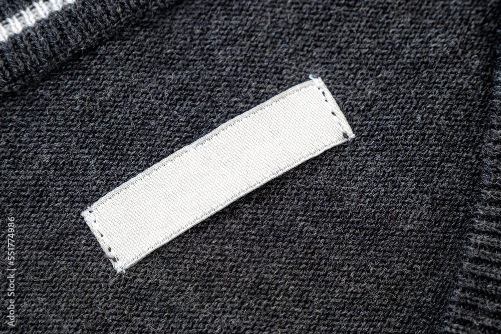White blank label, patch or tag with space for text on knitted gray ...