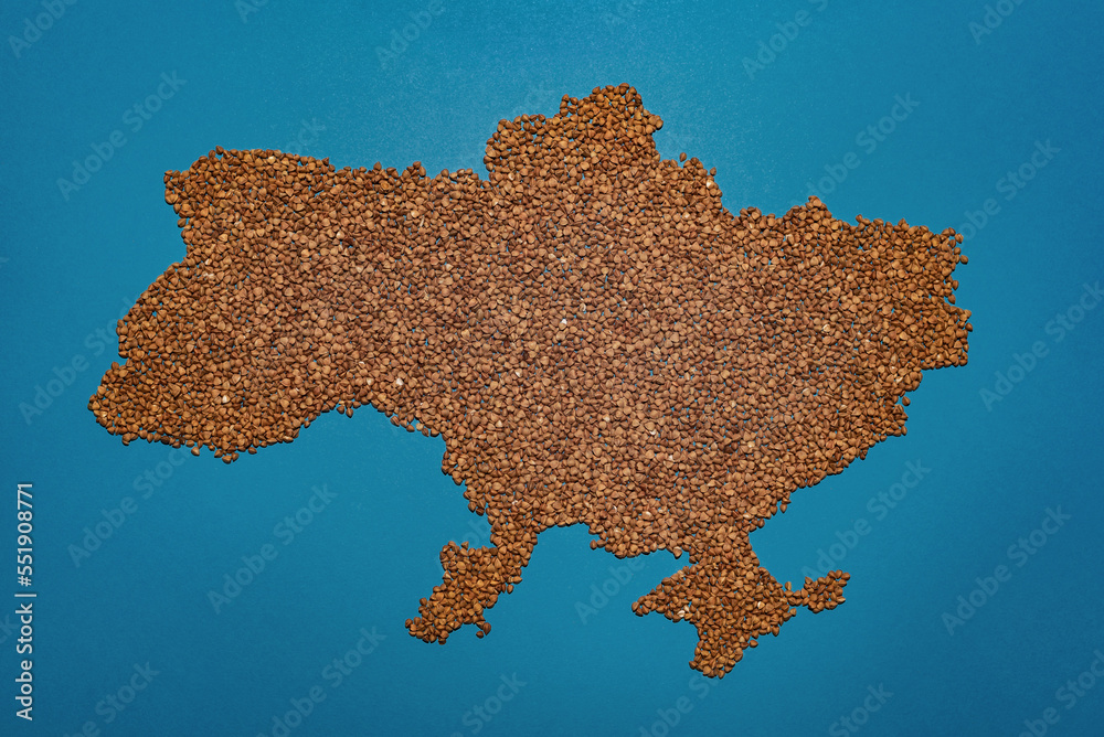 buckwheat grains on a blue background in the shape of a map of Ukraine ...