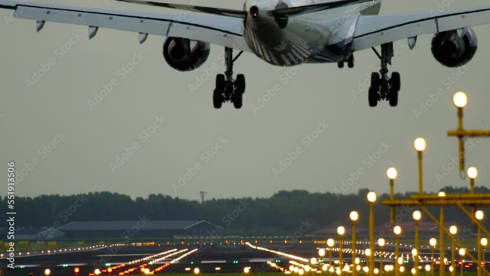 Cinematic footage of a widebody aircraft landing and braking, rear view ...