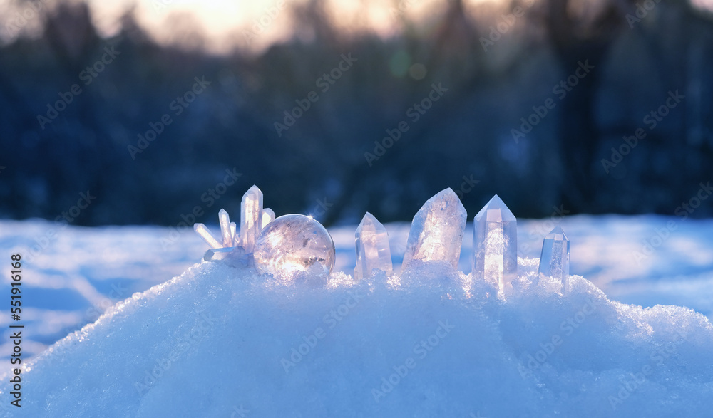 Clear quartz minerals on snow, natural blurred winter background ...