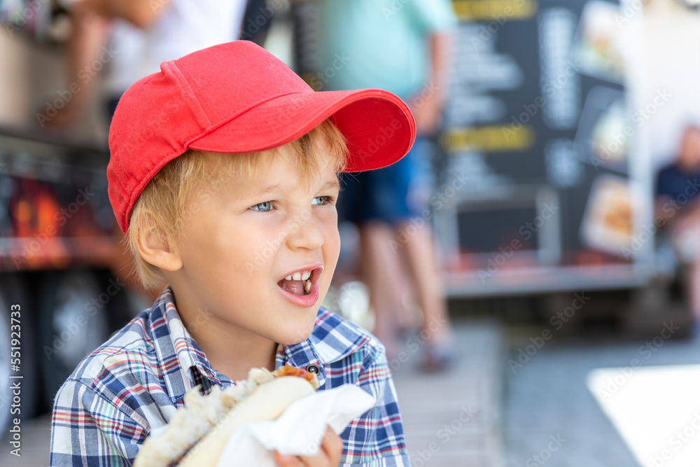 Cute adorable little happy smiling boy kid enjoy eating hot dog sausage ...