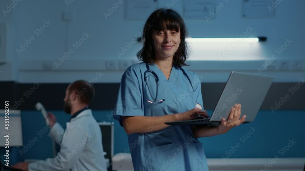 Assistant in blue uniform holding laptop computer analyzing patient ...
