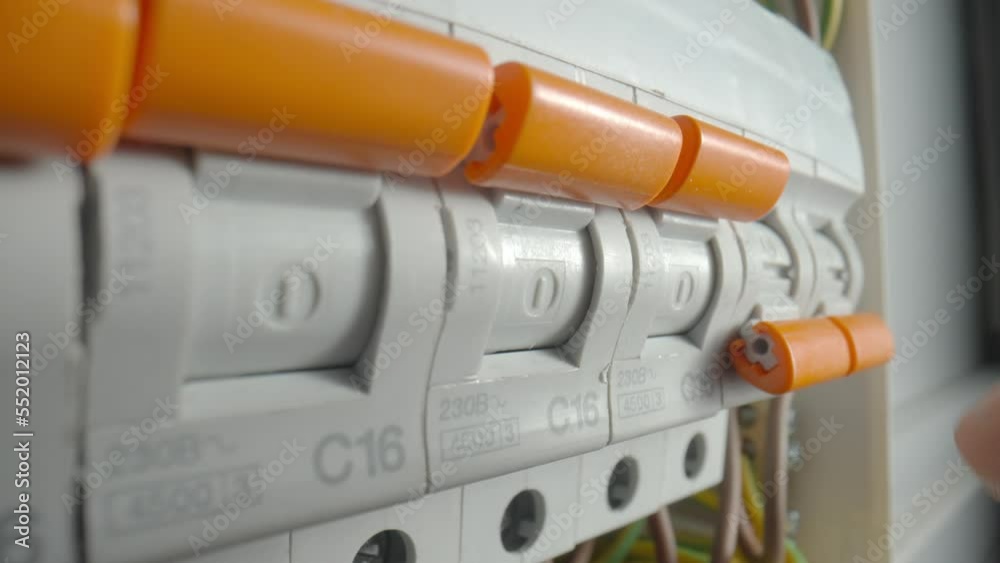 Finger turning on high voltage electrical switches in switchboard ...