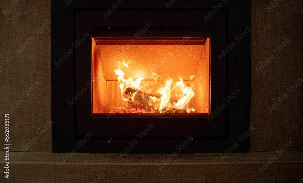 Fire flames and burning wood logs, fireplace on a wall, warm home in ...