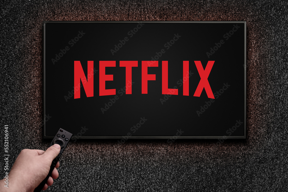 Man turns on TV with remote control. Netflix logo on TV screen. Netflix ...