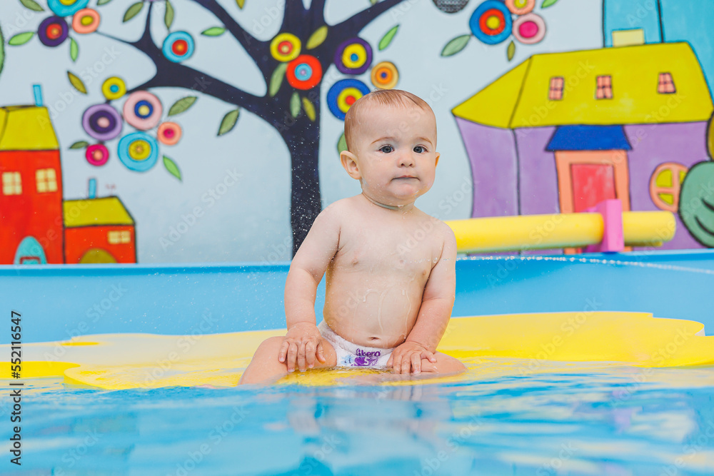 Swimming lessons for children. A little boy is learning to swim in a ...