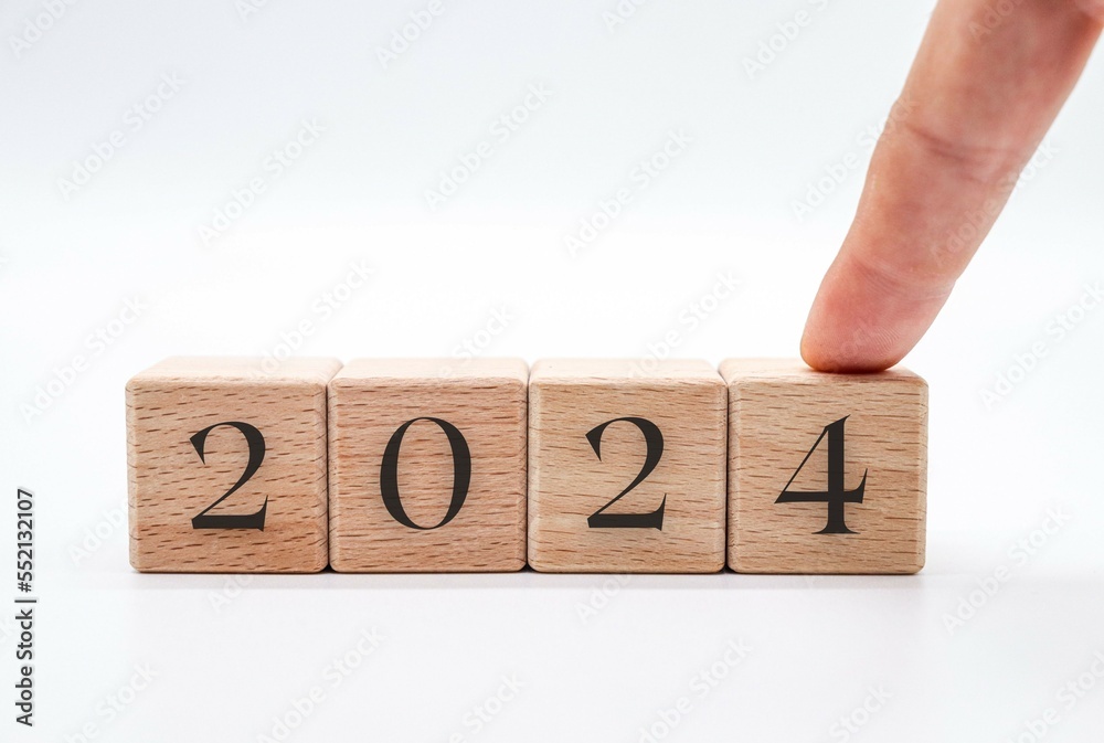 Hand choosing the number 2024 in wooden block cubes isolated on a white ...