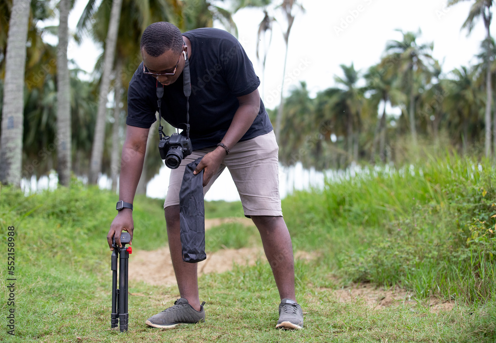 Portrait of a young black African photographer unpacking his ...