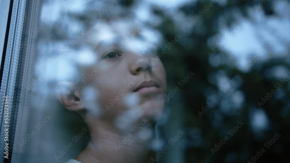 Vidéo Stock sad boy near the window, looks thoughtfully with experience ...