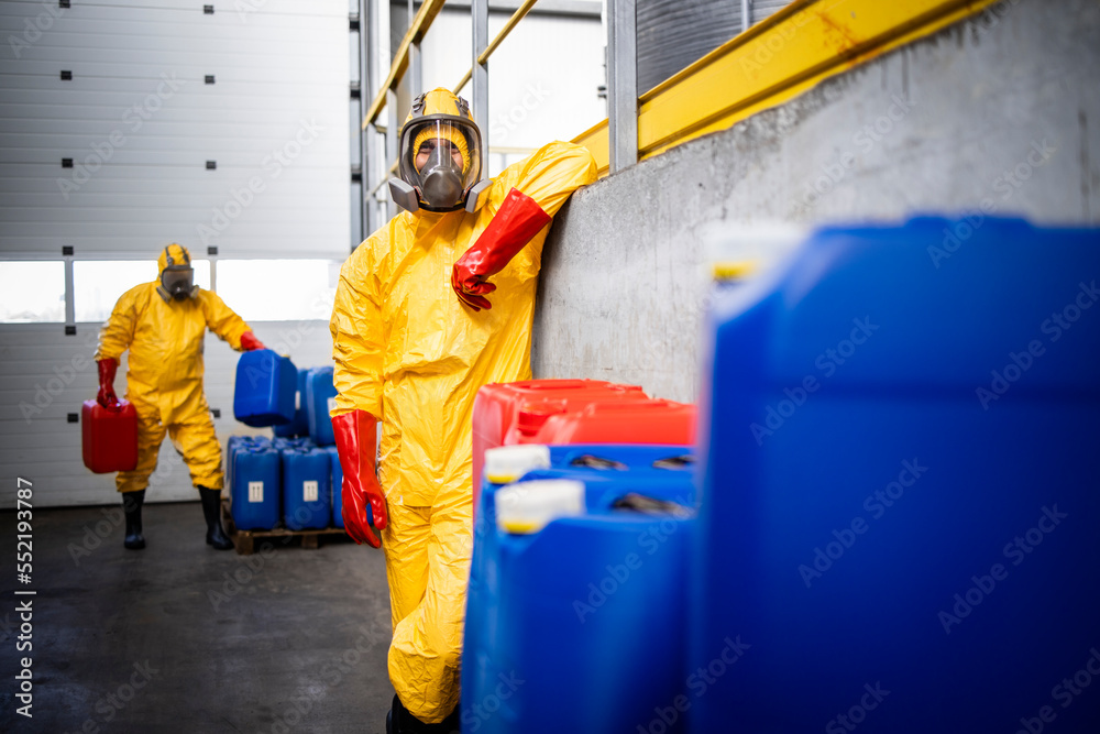 Portrait of chemical plant worker in hazmat protection suit standing by ...