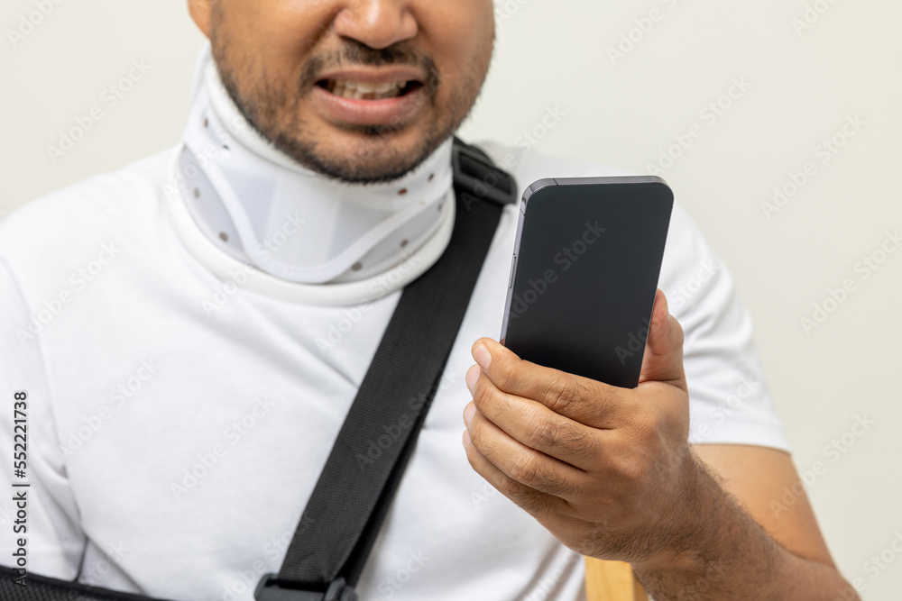 Foto de Young man broken arm holding smartphone. Asian man put on ...