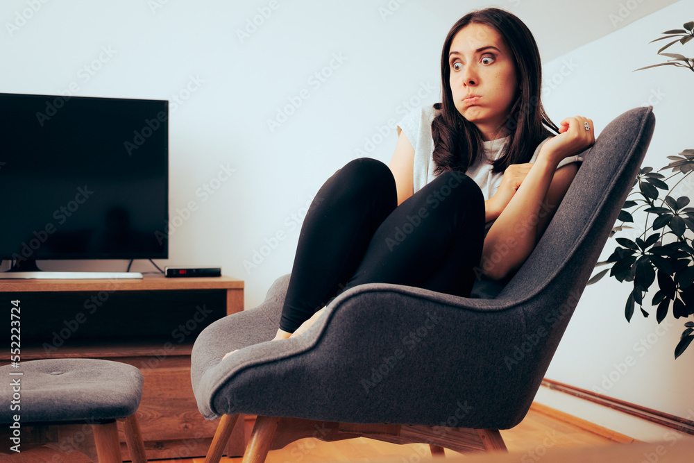 Woman Crouched in an Armchair Scared of pests in her Home. Fearful ...
