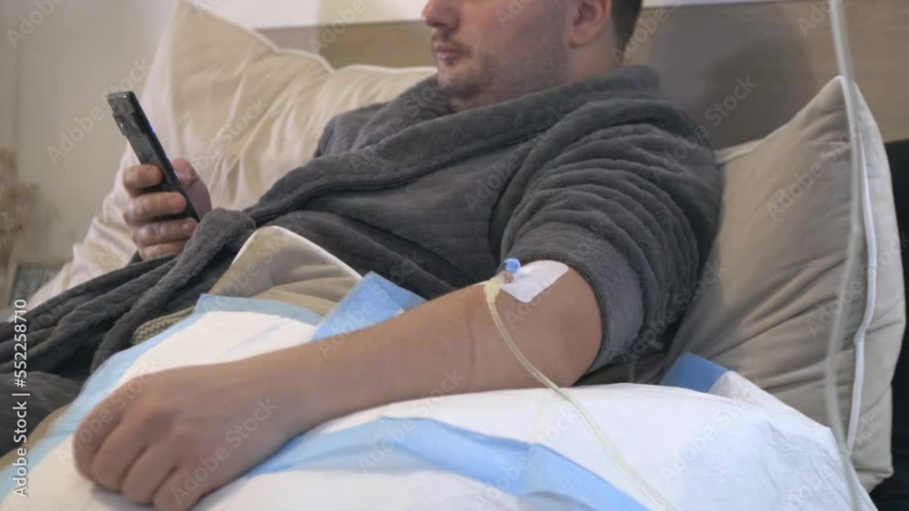 zoom in patient sitting on hospital bed room while receiving a dextrose ...