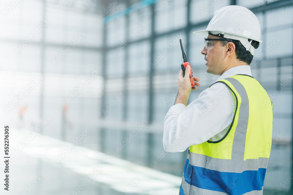 warehouse manager with tablet and ..radio communication his worker ...