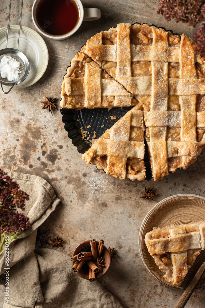 Sliced homemade apple pie served with plates, tea and cutlery, top view ...